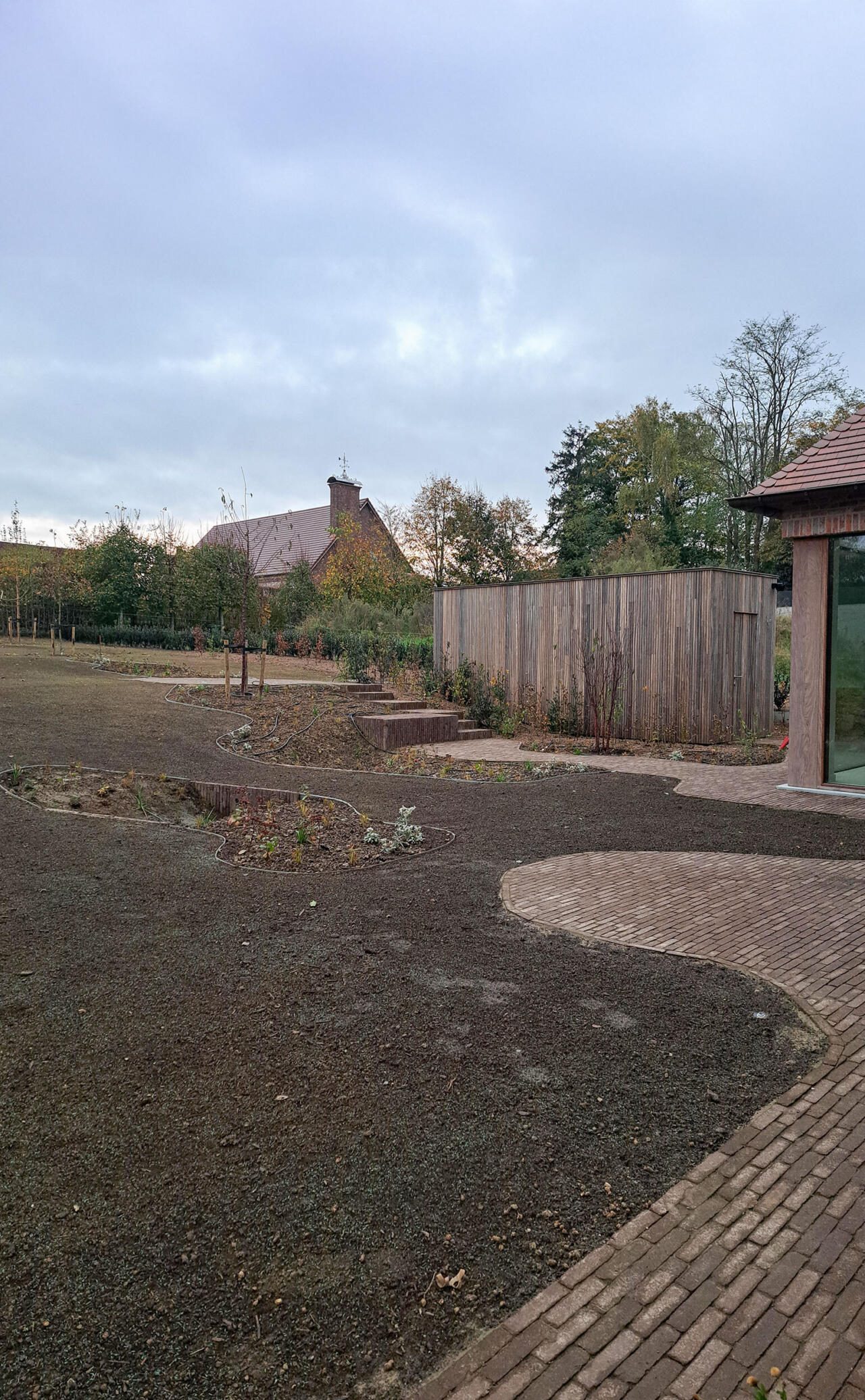 Hellende tuin met wadi voor waterinfiltratie | Greenarchitects